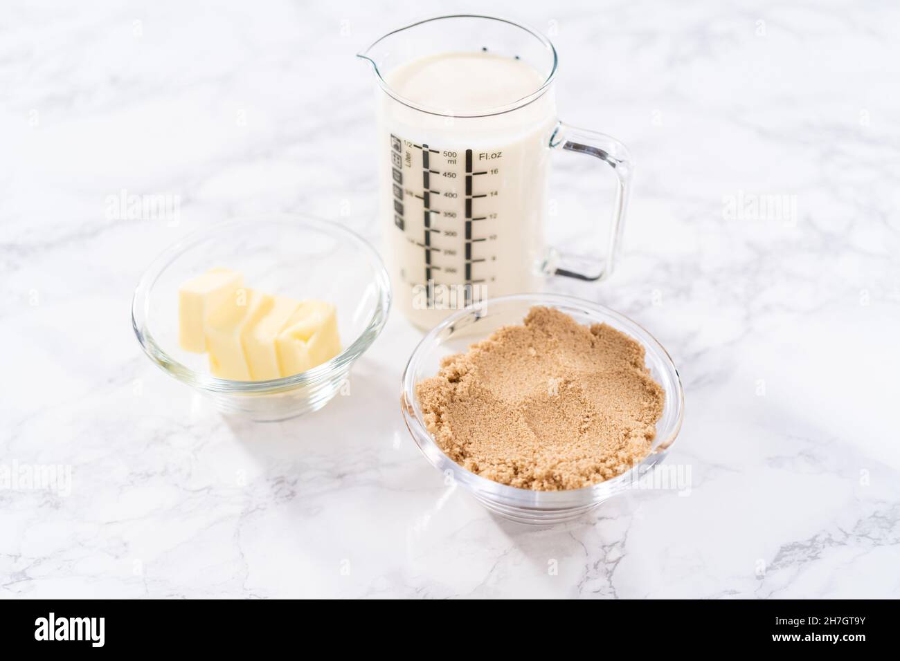 Measured ingredients in a glass mixing bowl to preparetoffee glaze ...