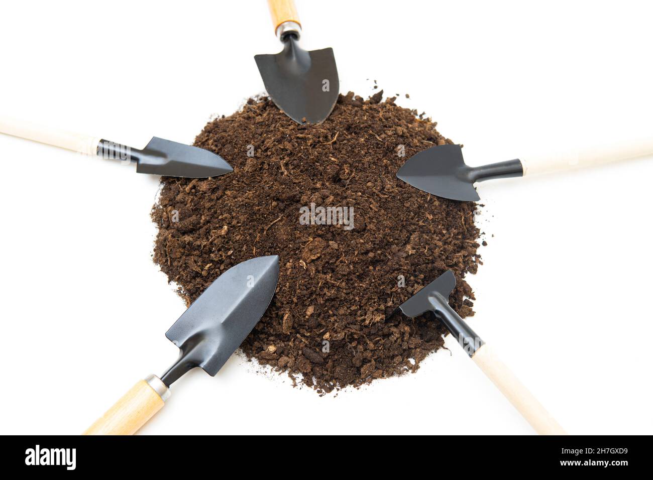 Selection of garden hand tools in a soil pile isolated on white ...