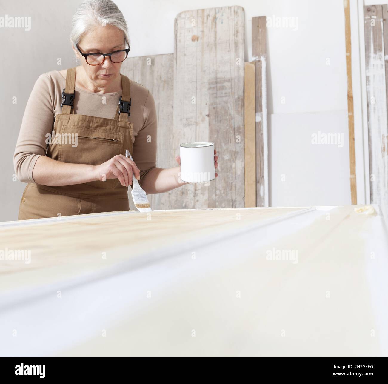 wood crafts, woman artisan carpenter painting with brush and paint jar ...