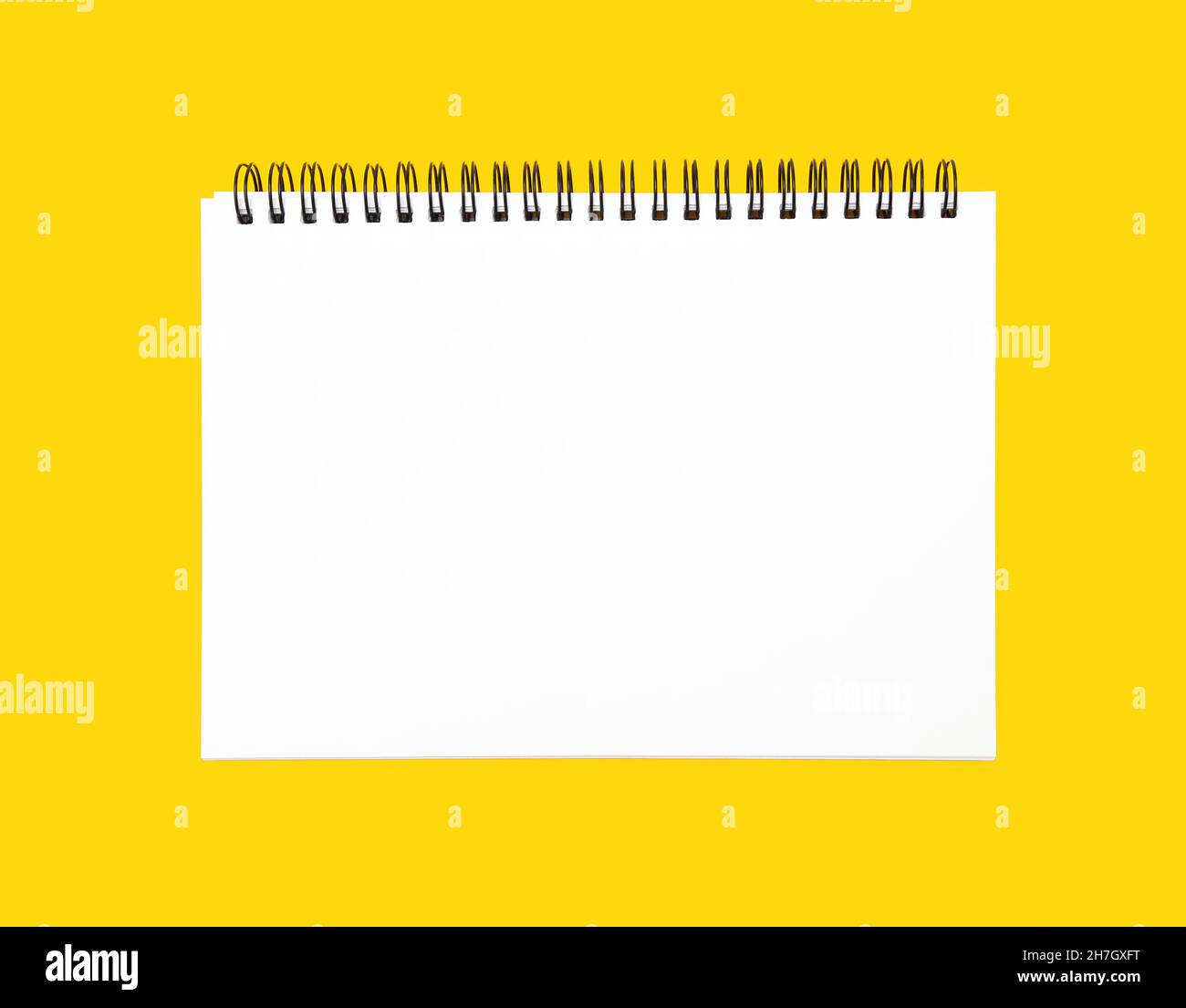Blank spiral bound notebook on a yellow background Stock Photo - Alamy