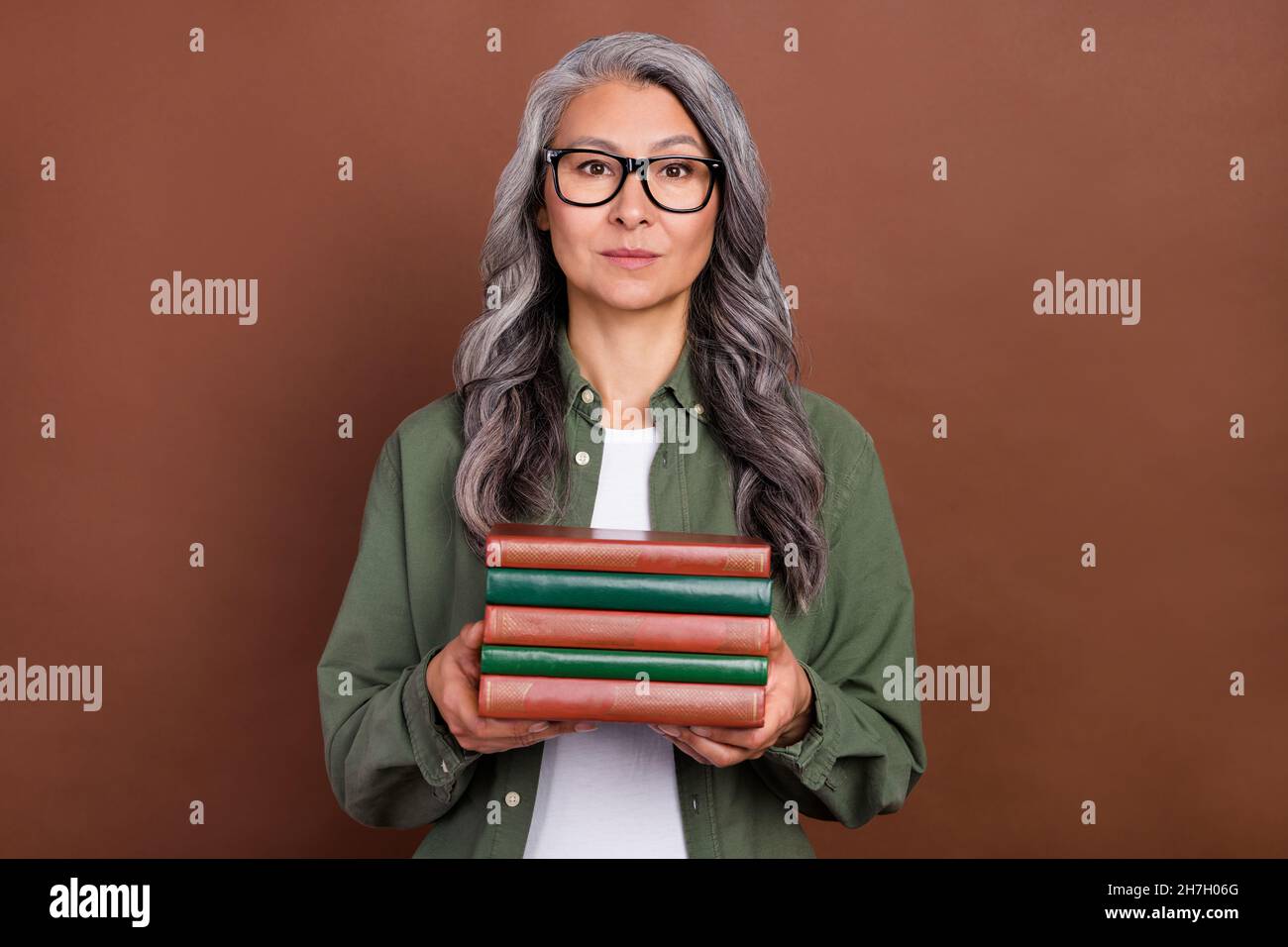 Photo of nice elder grey hairdo lady hold books wear khaki shirt ...