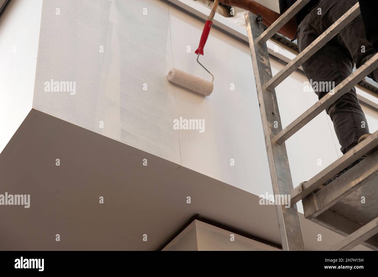 Worker painting wall on ladder.Stock photo Stock Photo - Alamy