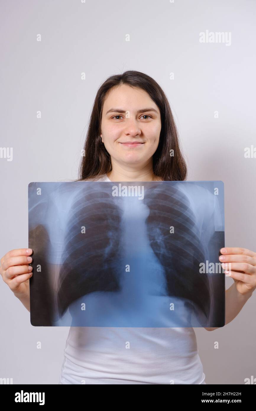 The woman holds an X-ray image of her lungs at chest level Stock Photo ...