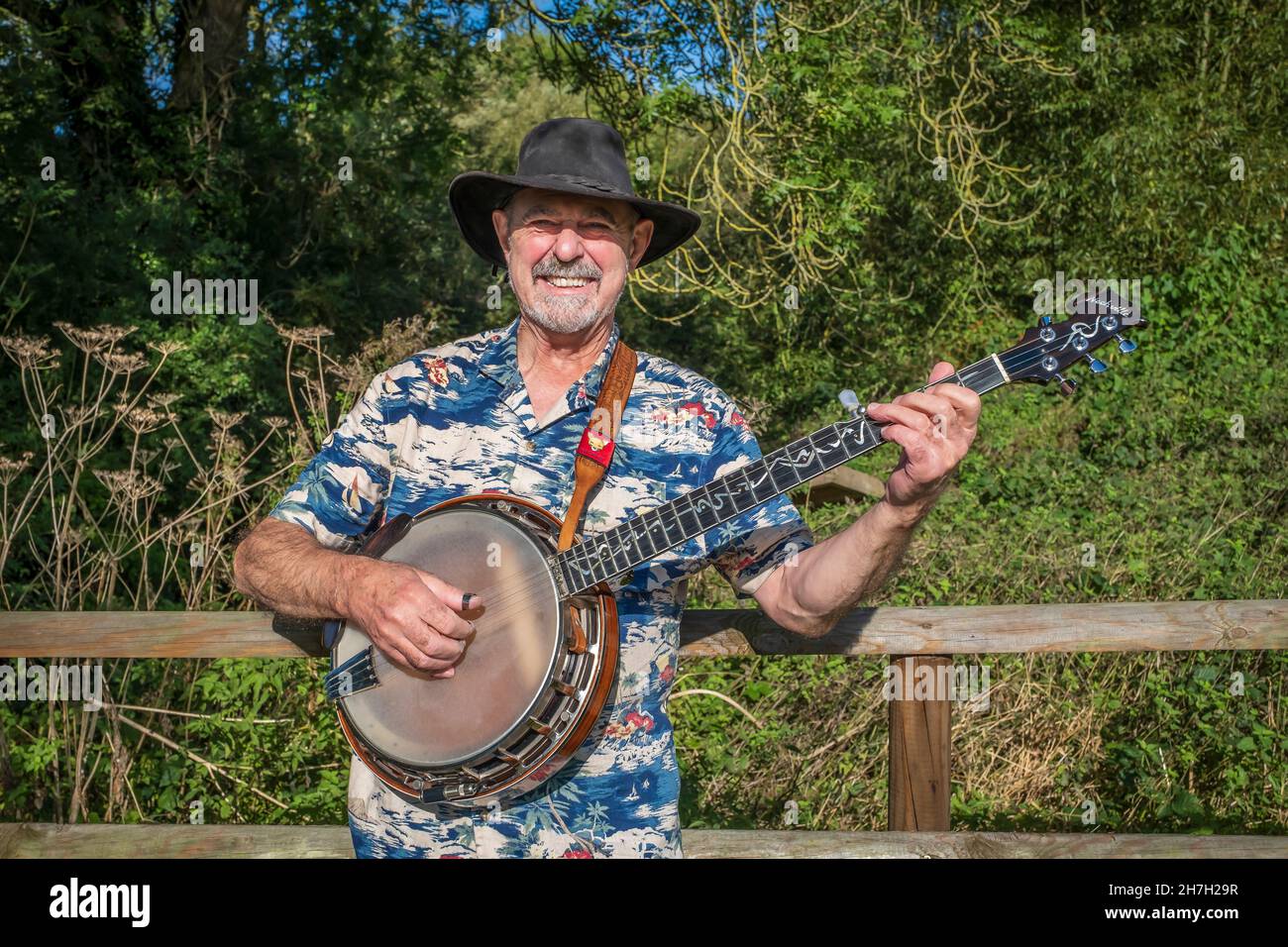 Man playing a banjo in the countryside Stock Photo - Alamy