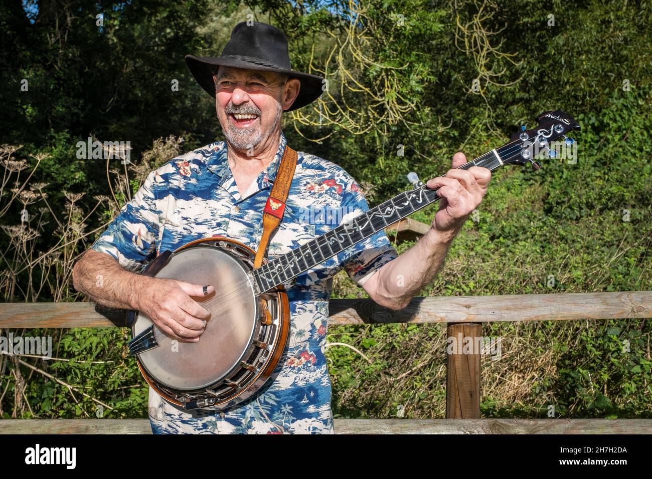 Man playing a banjo in the countryside Stock Photo - Alamy