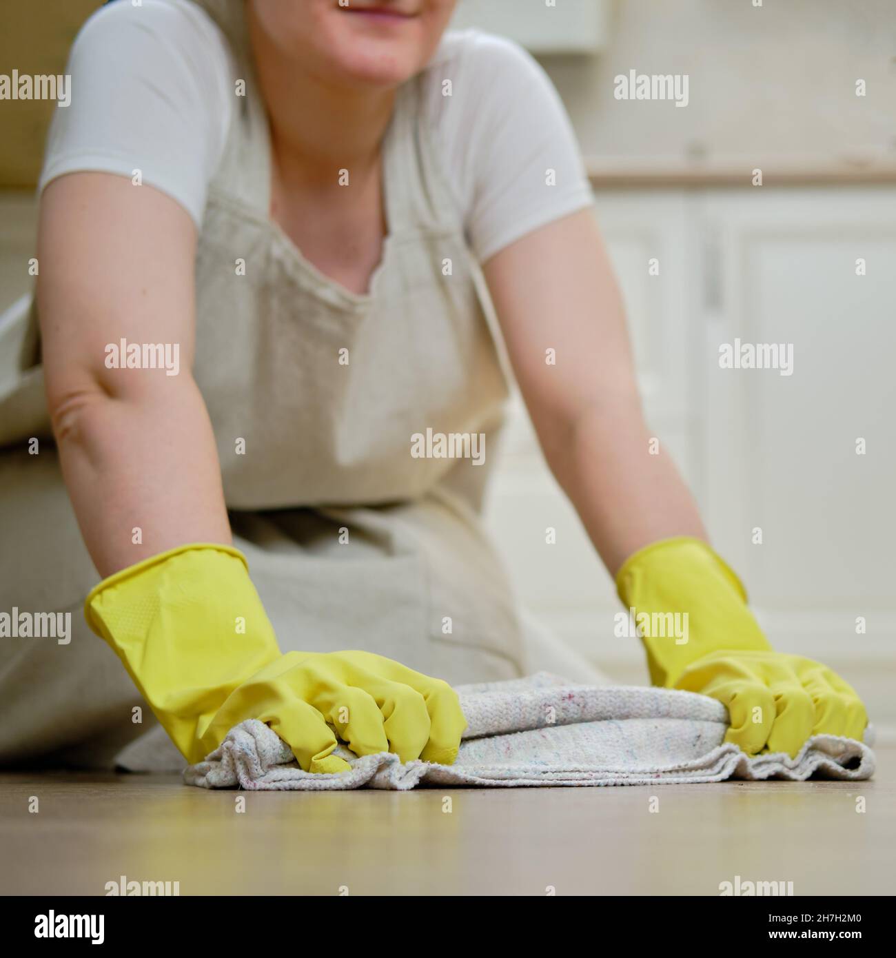 A woman washes the floor with a rag when cleaning the home kitchen ...