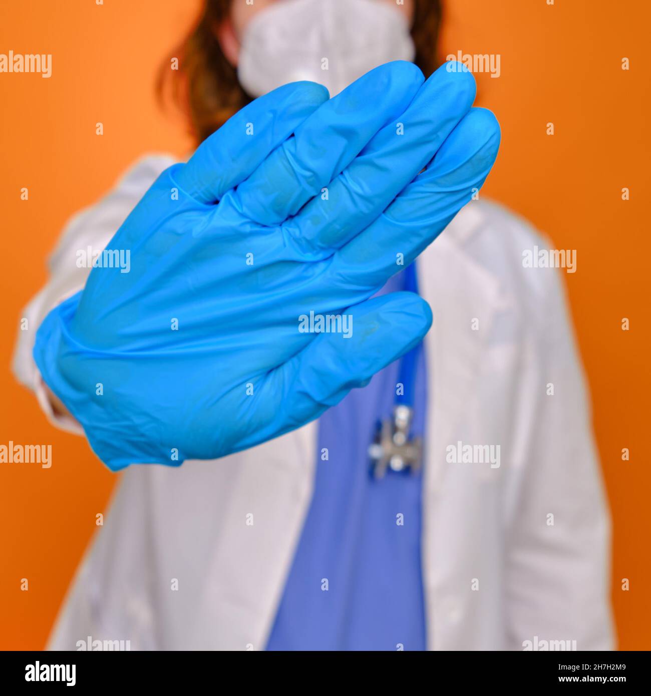 Doctor shows gesture of refusal by hand, stay home. Doctor woman on a ...