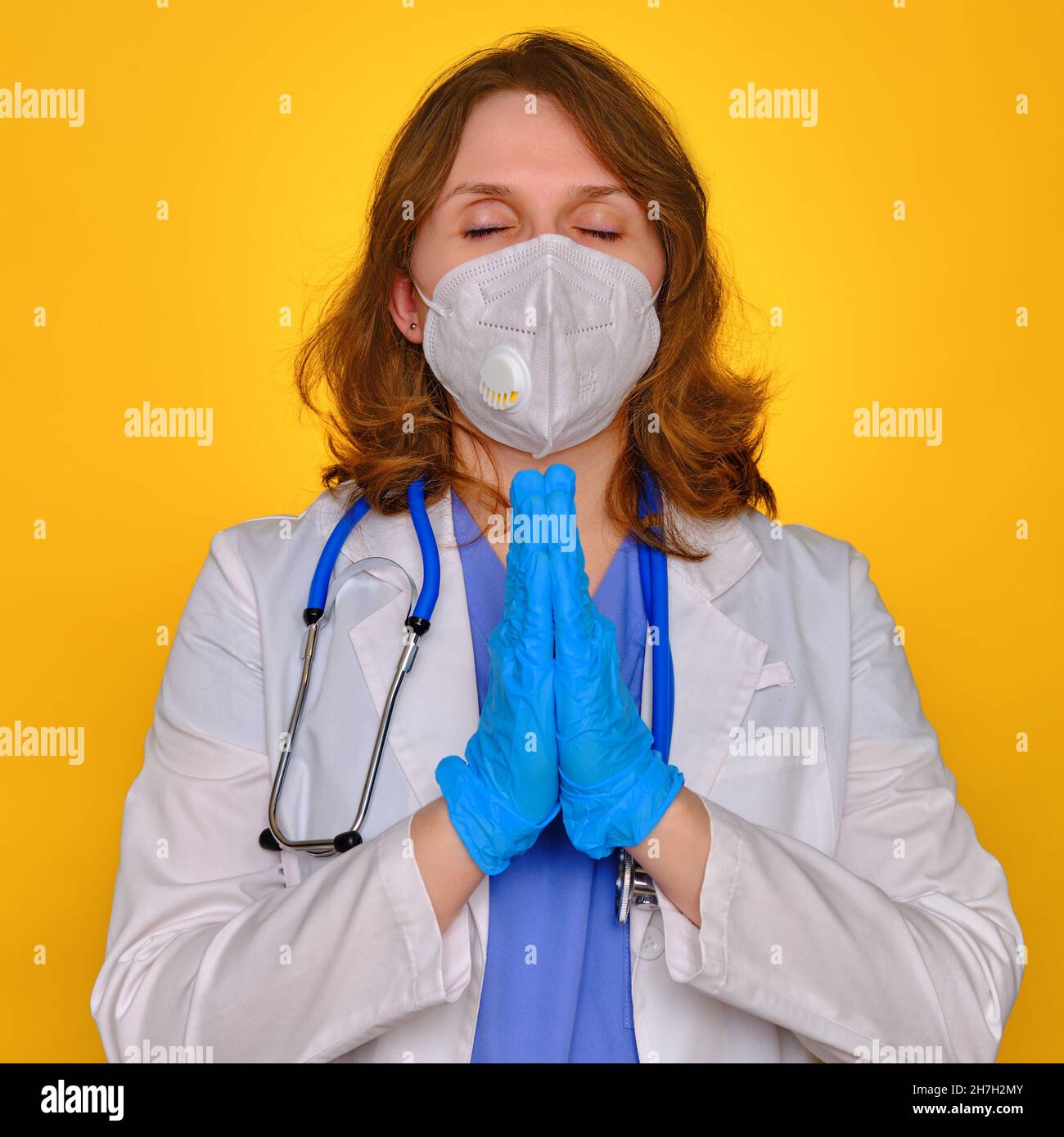 Doctor praying to god with folded hands in prayer near his face, studio ...