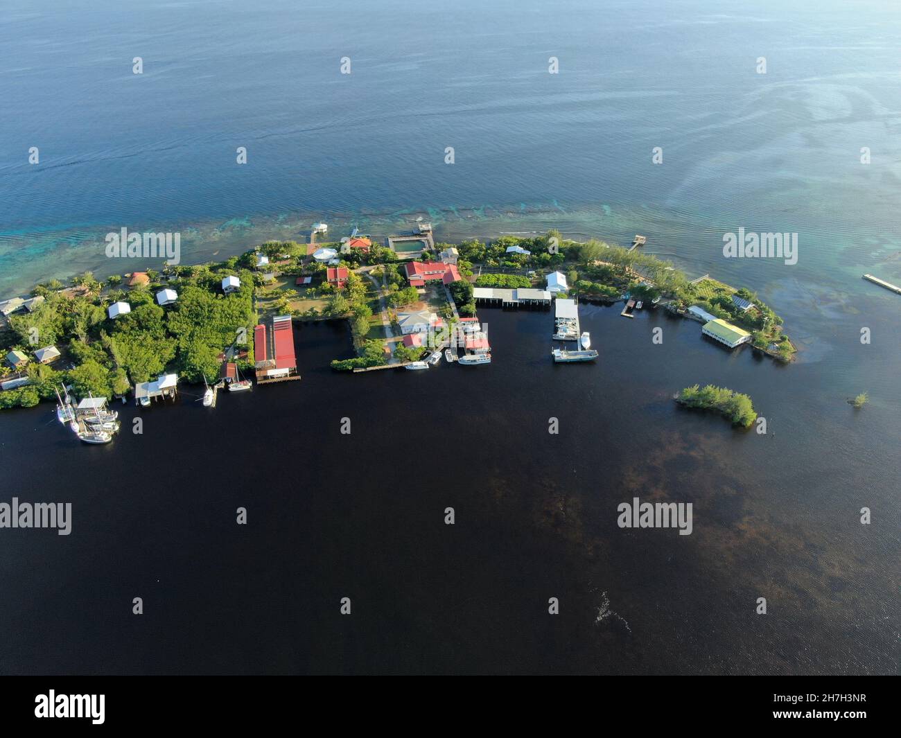 Aerial shot over the beautiful and green island of Utila and the ...
