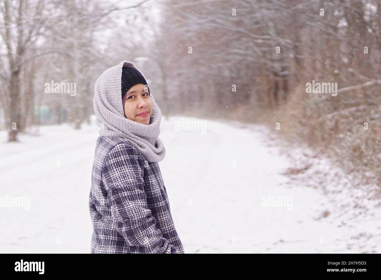 Young Southeast Asian Muslim girl posing in the park during winter ...