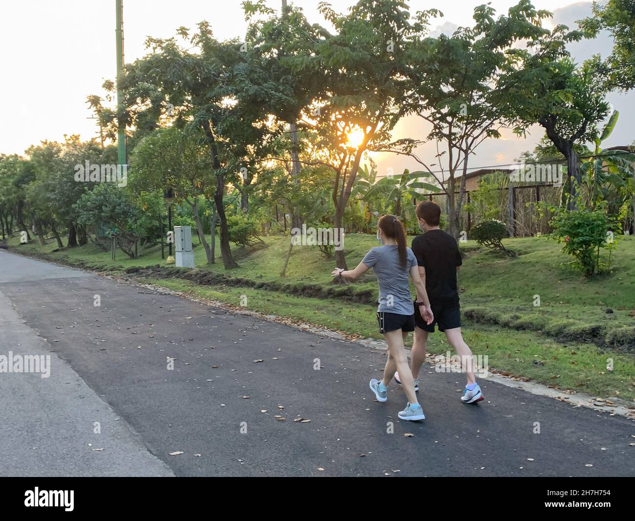 Couple exercise walking together in the park at sunset Healthy ...