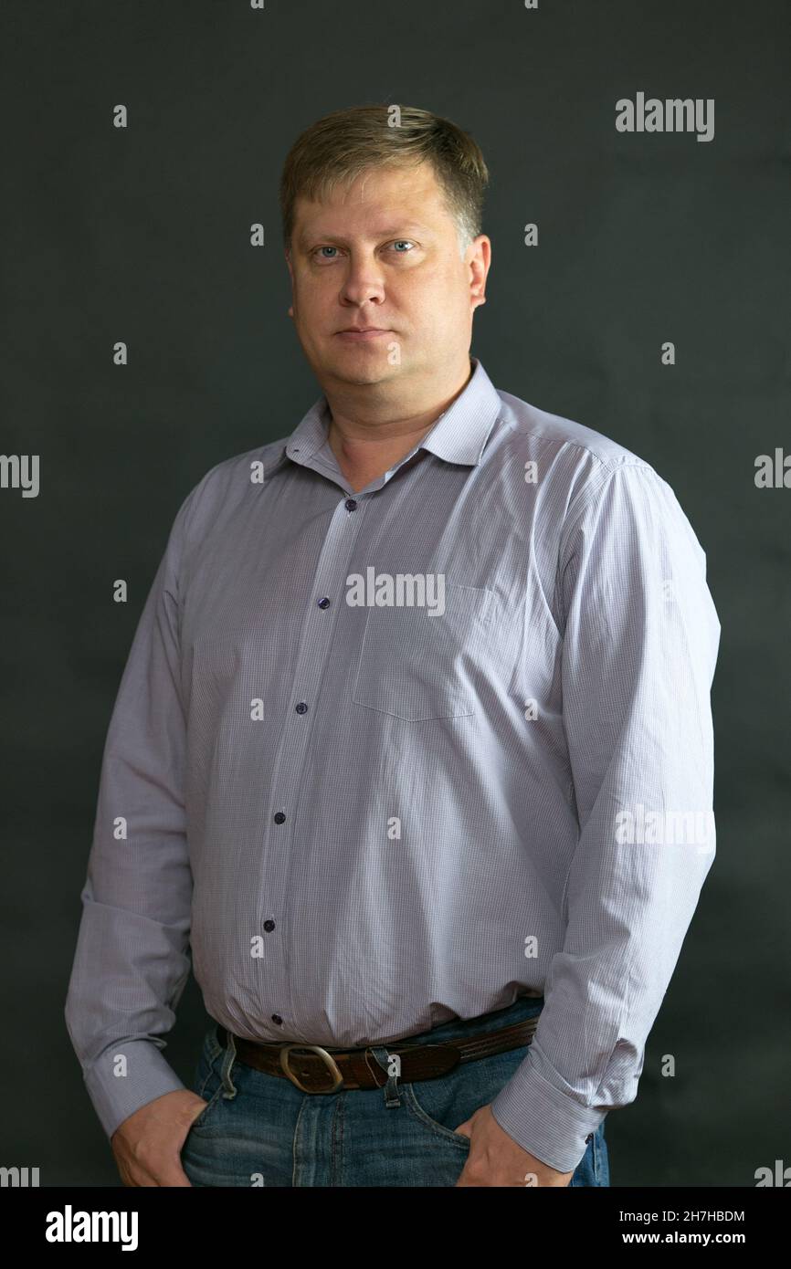 Adult tall blonde 40 years old in a strict shirt on a black background ...