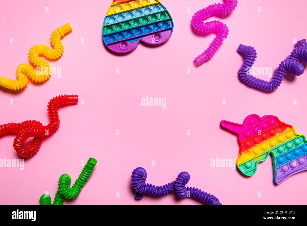 Yallow, red, purple, pink and green pop tube children toys bent in ...