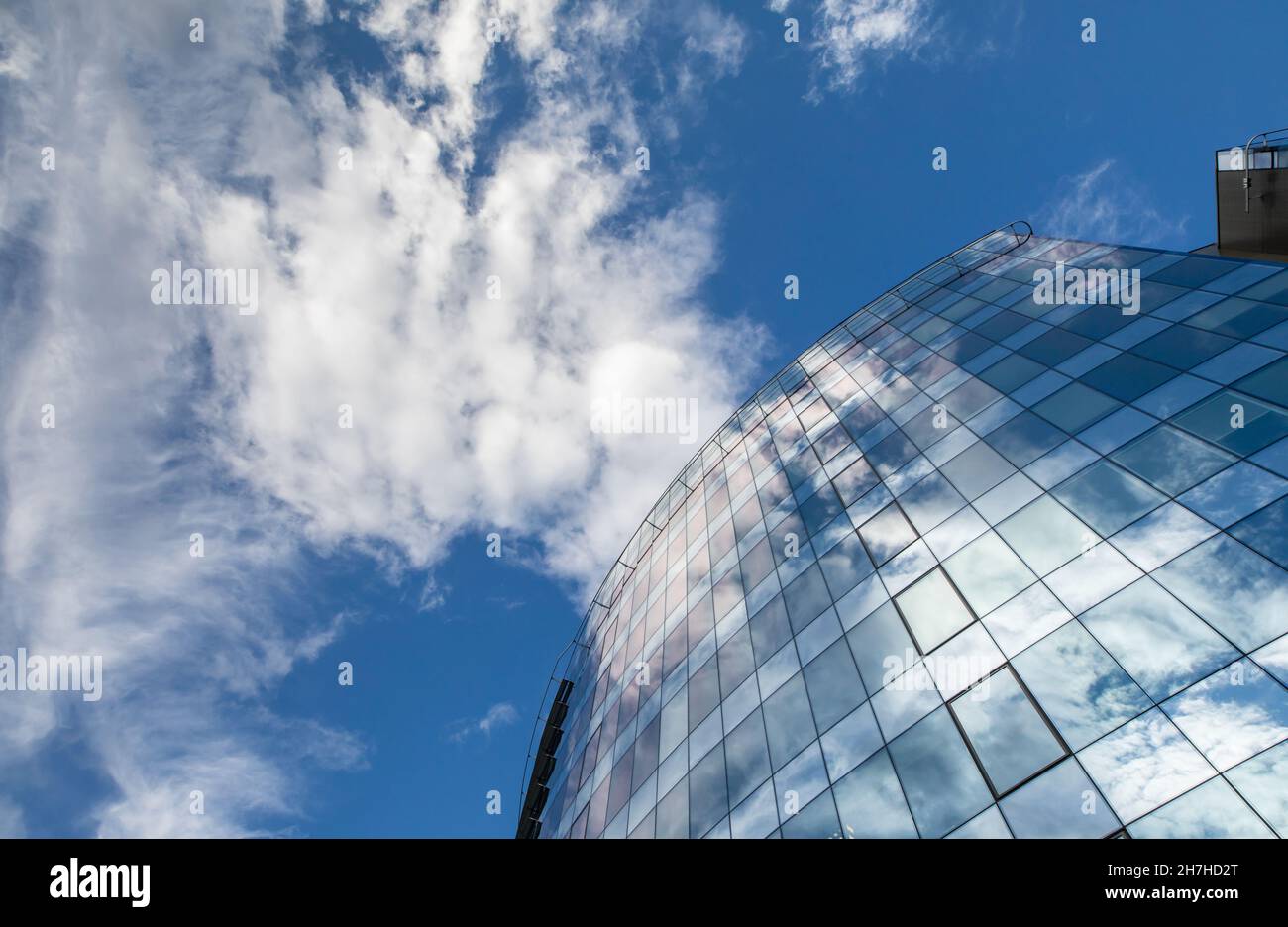 Elements of the glass facede skyscraper with reflecting sky and clouds ...