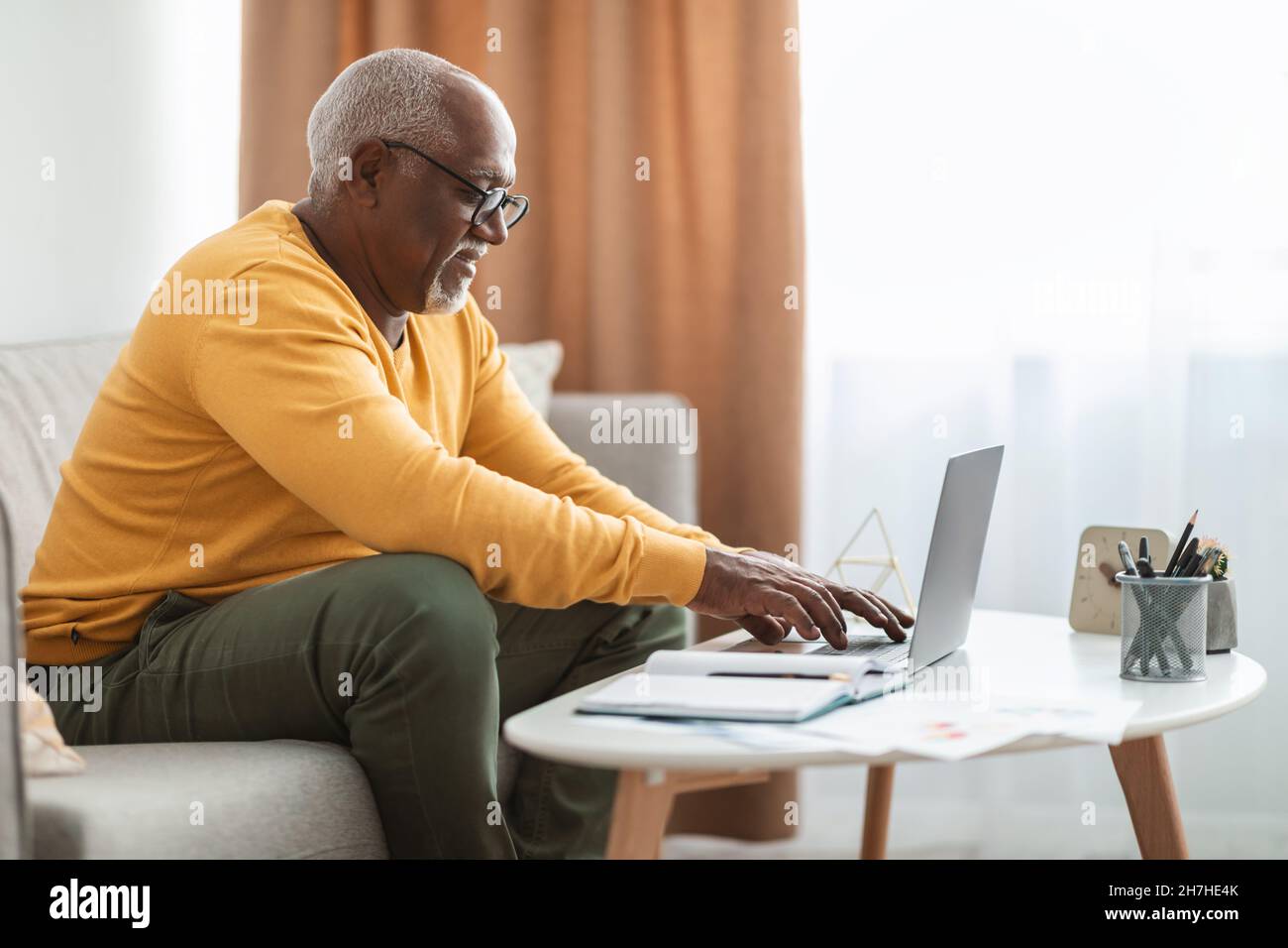 Side-View Of Mature Black Man Typing On Laptop At Home Stock Photo - Alamy