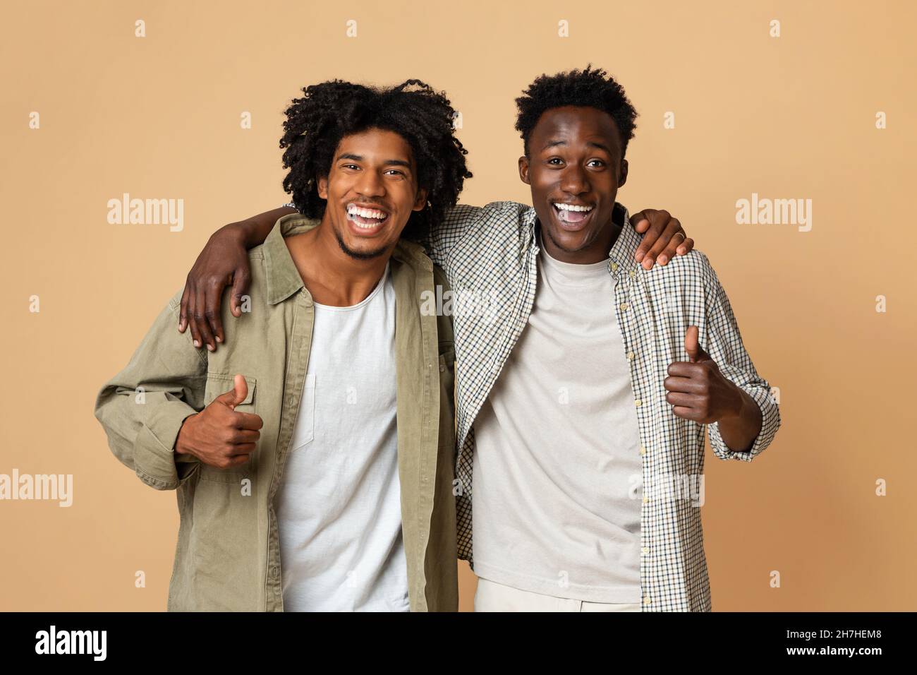Two Happy Excited Black Guys Embracing And Showing Thumbs Up At Camera ...