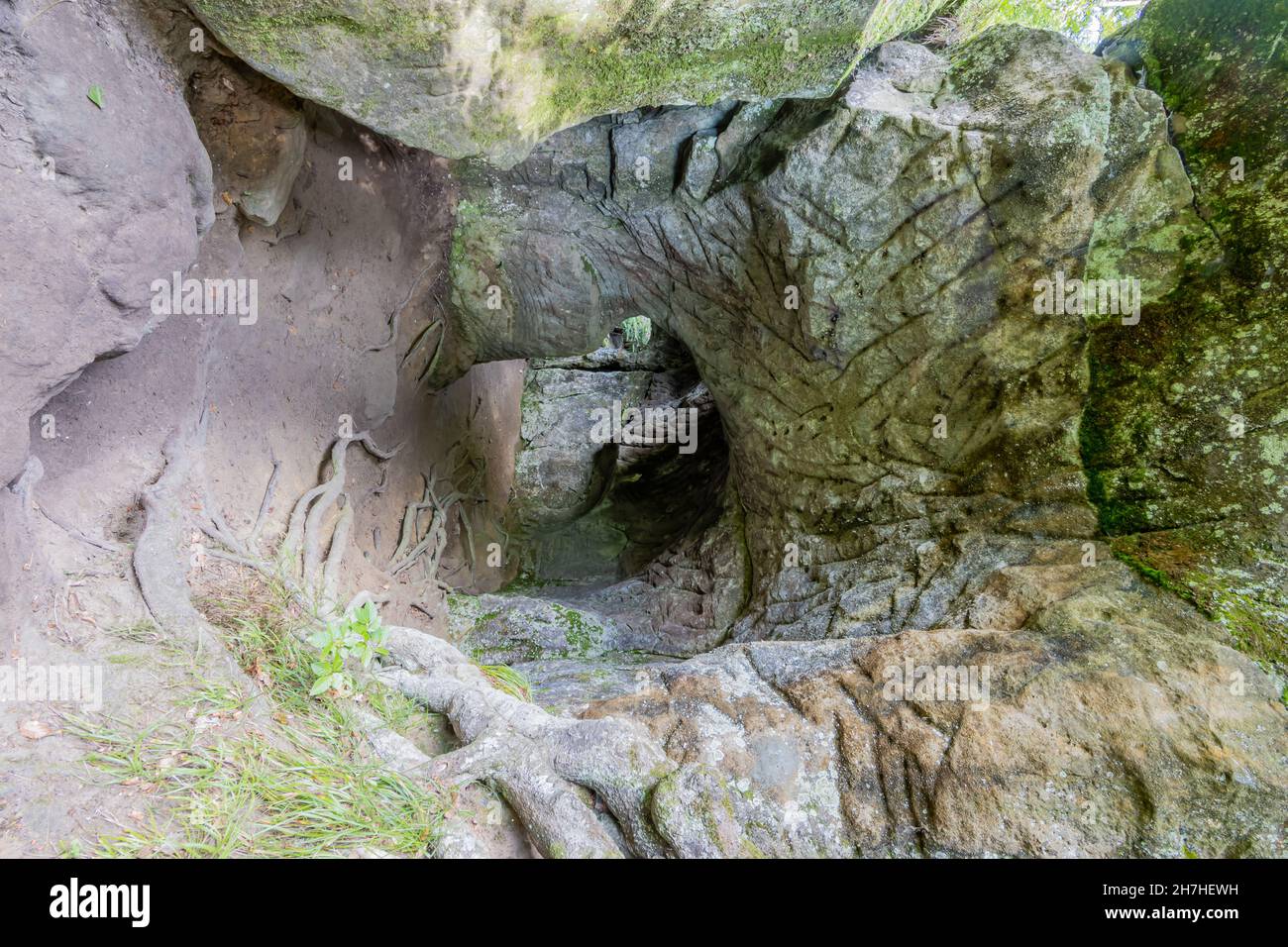 Dirt road in the direction of a cave crossing a huge sandstone rock ...