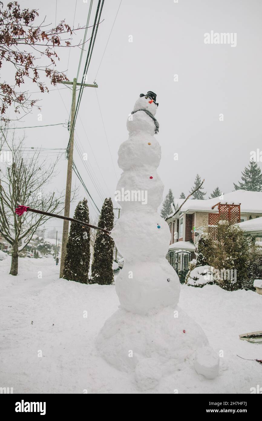 Vertical shot of a tall snowman in a backyard Stock Photo - Alamy