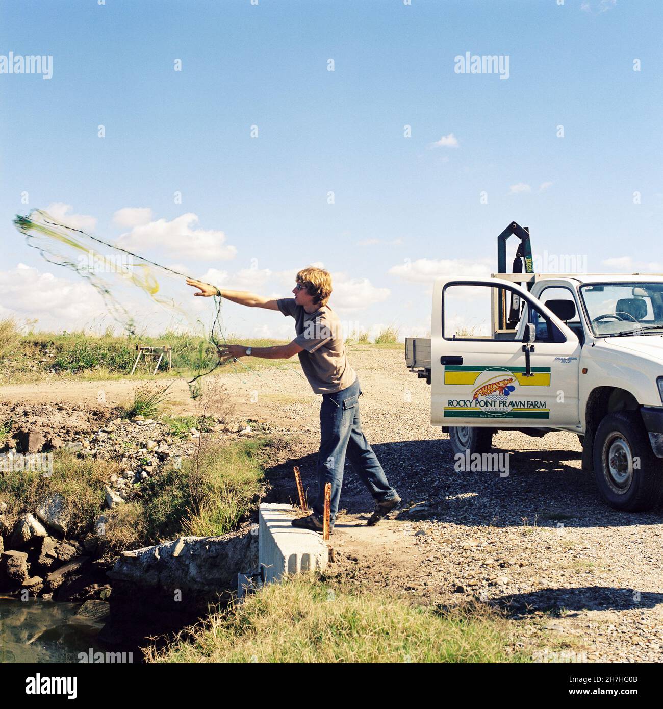 Cast net fishing in the ditches outside the prawn farms where fish ...