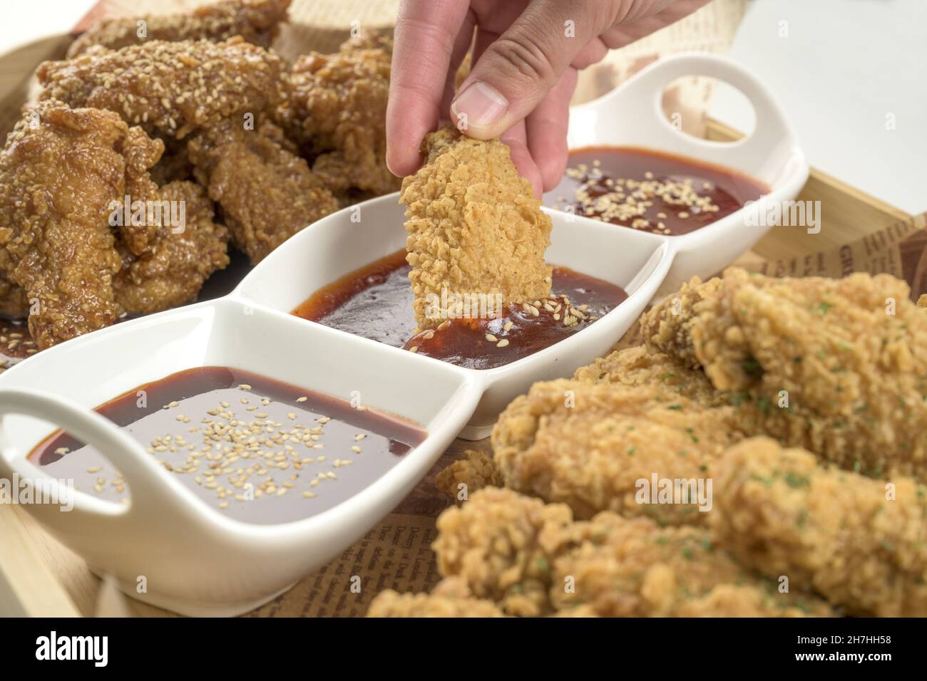 Closeup shot of Korean fried chicken with dipping sauce isolated on a ...