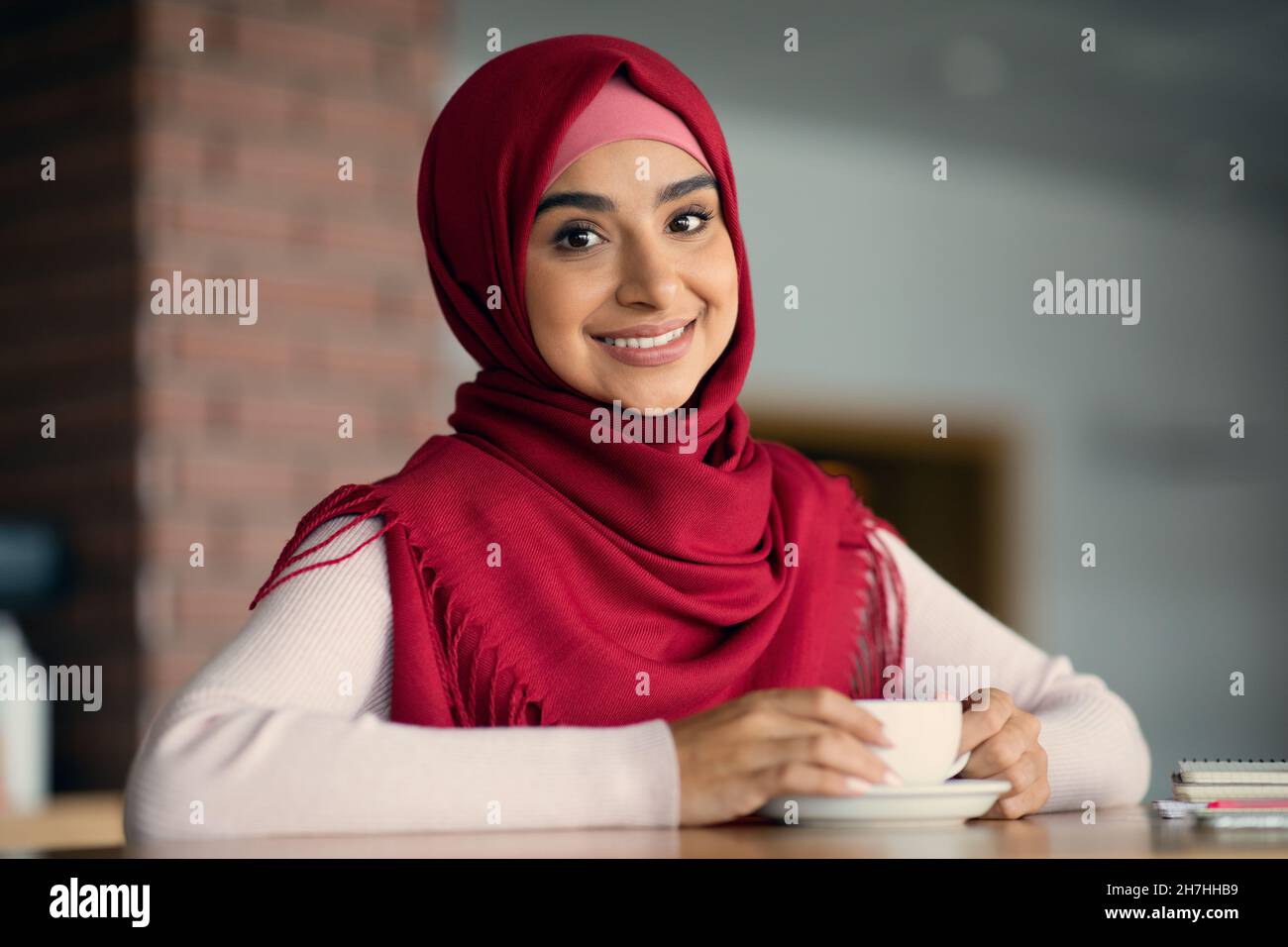 Attractive muslim woman in hijab posing at cafe Stock Photo - Alamy