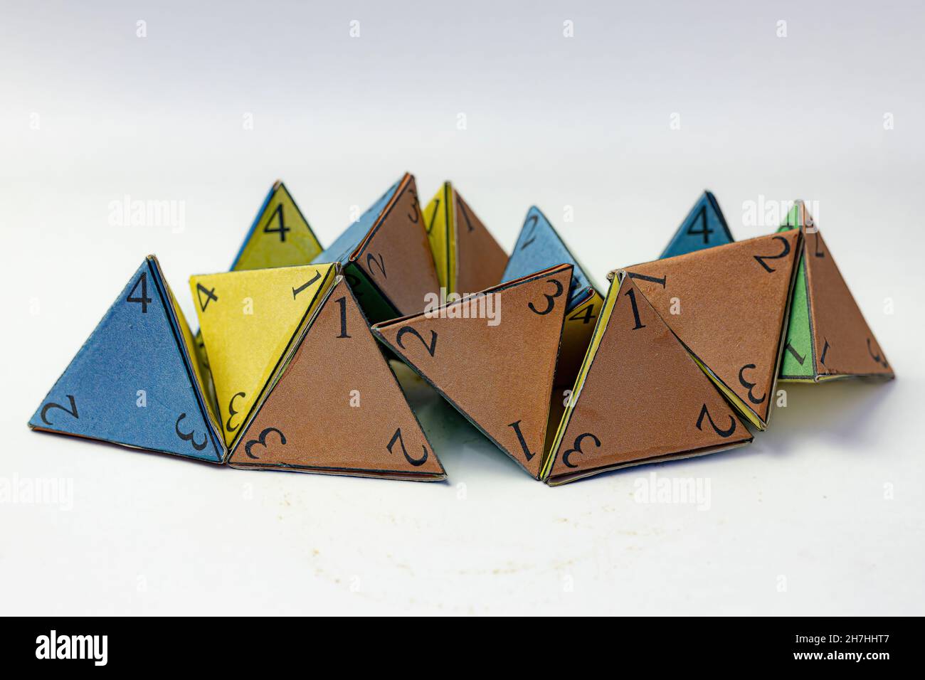 Handmade colored tetrahedral numbered dice on paper Stock Photo - Alamy