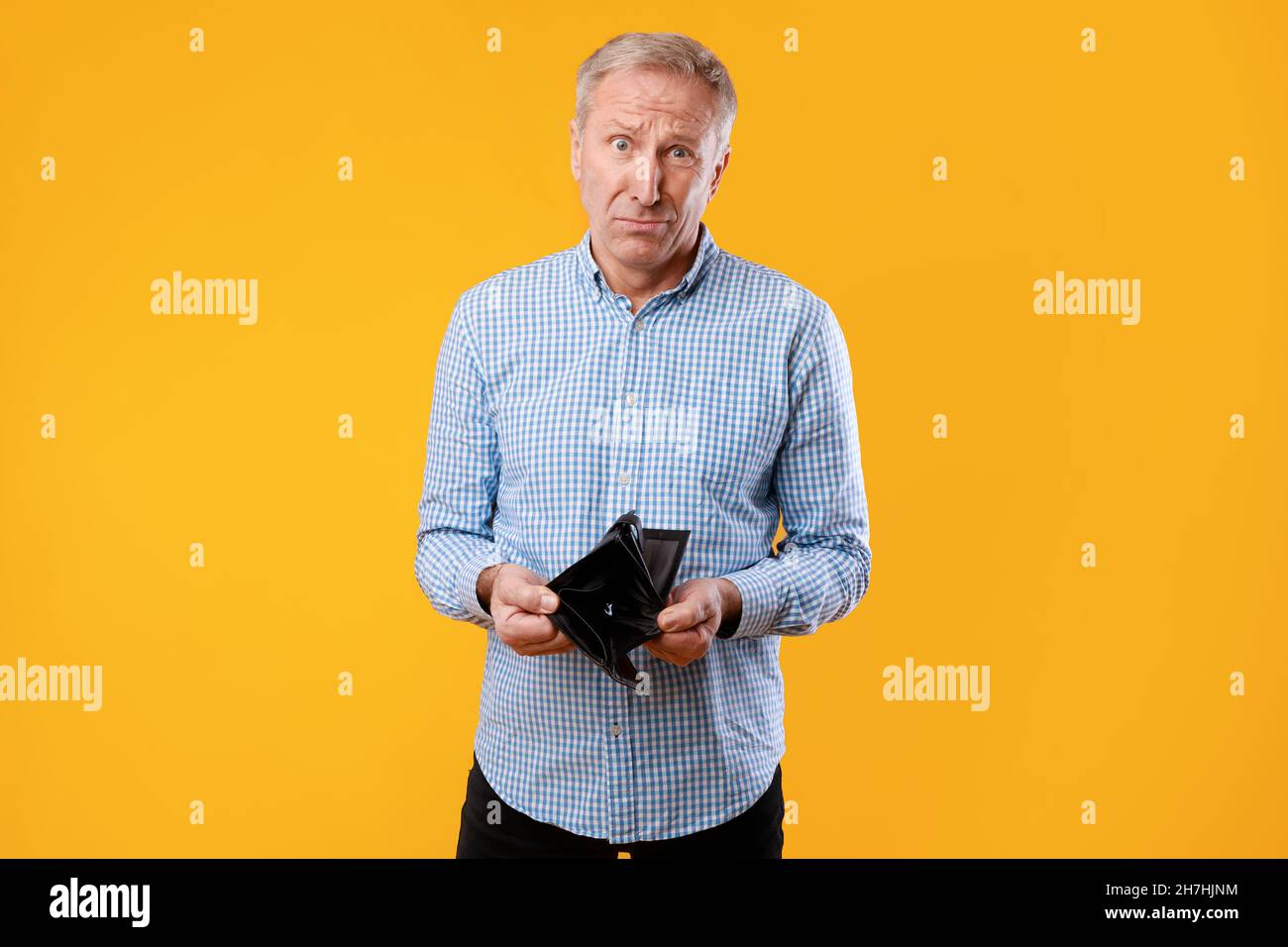Portrait of mature man showing his empty wallet Stock Photo - Alamy