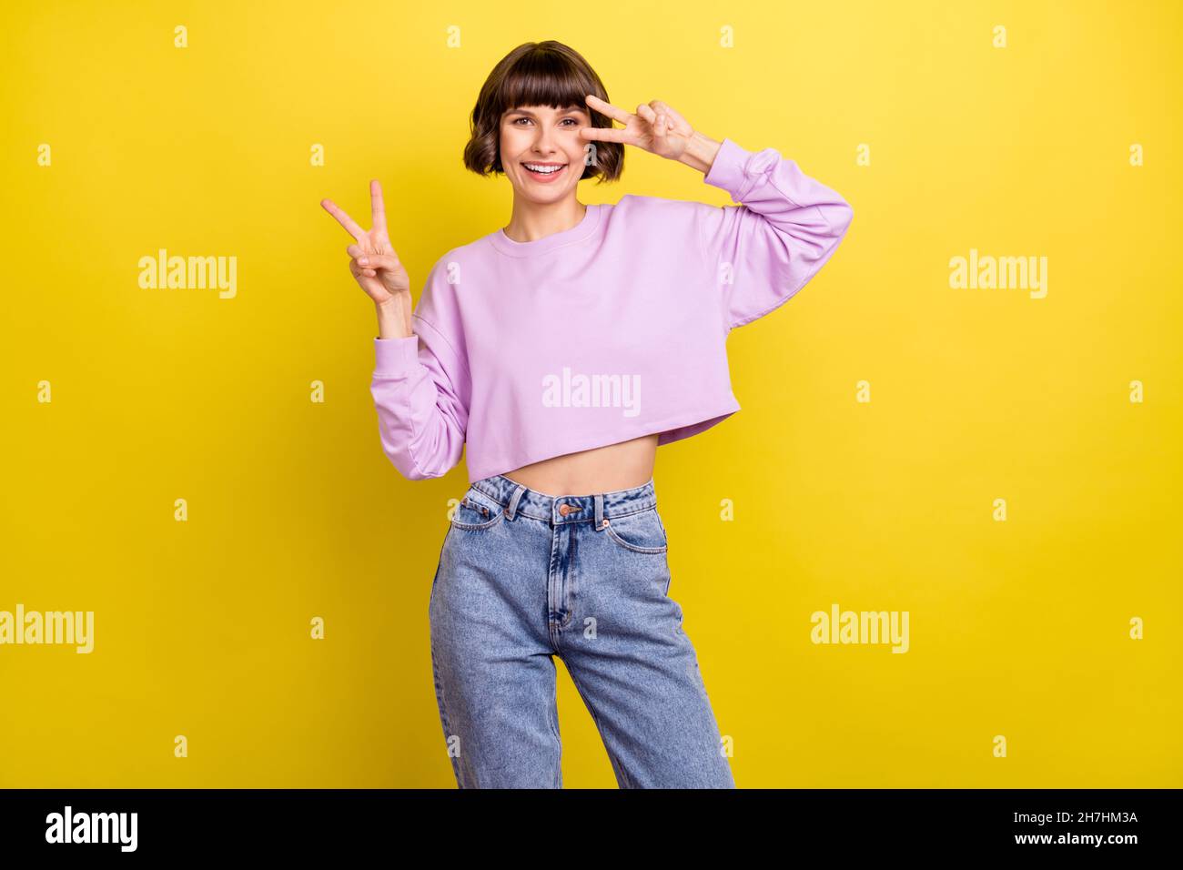 Portrait of attractive cheerful girl showing double v-sign having fun ...