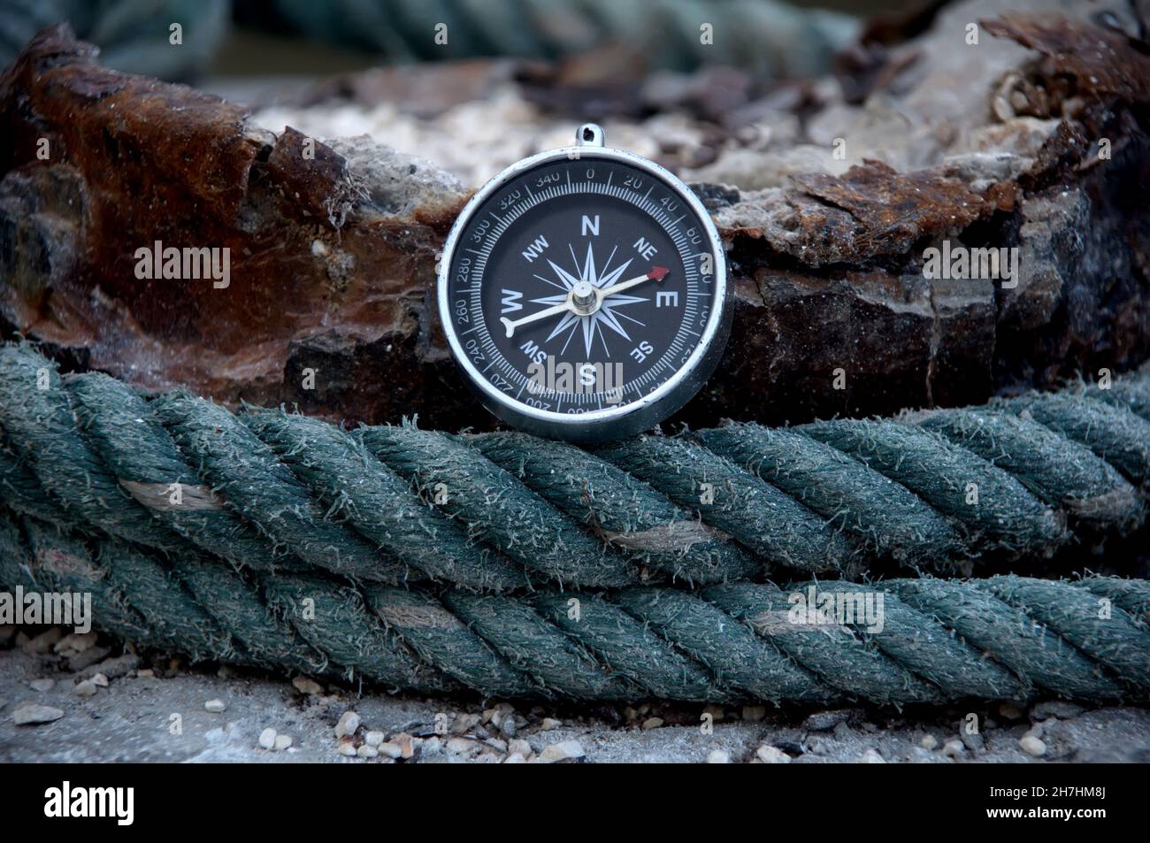 Navigation compass in harbor with big rope around it Stock Photo - Alamy