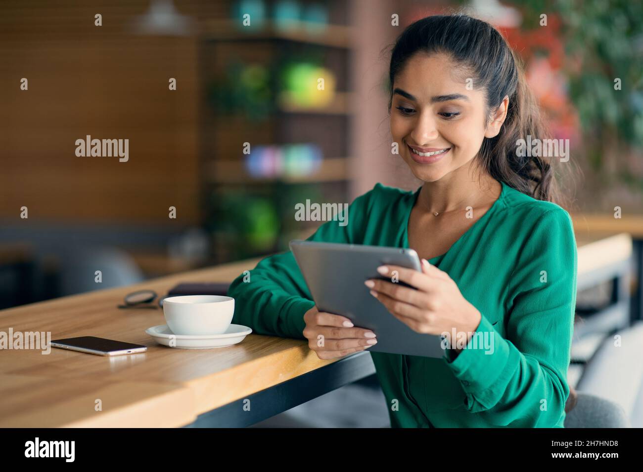 Cheerful indian lady SMM manager working from cafe Stock Photo - Alamy
