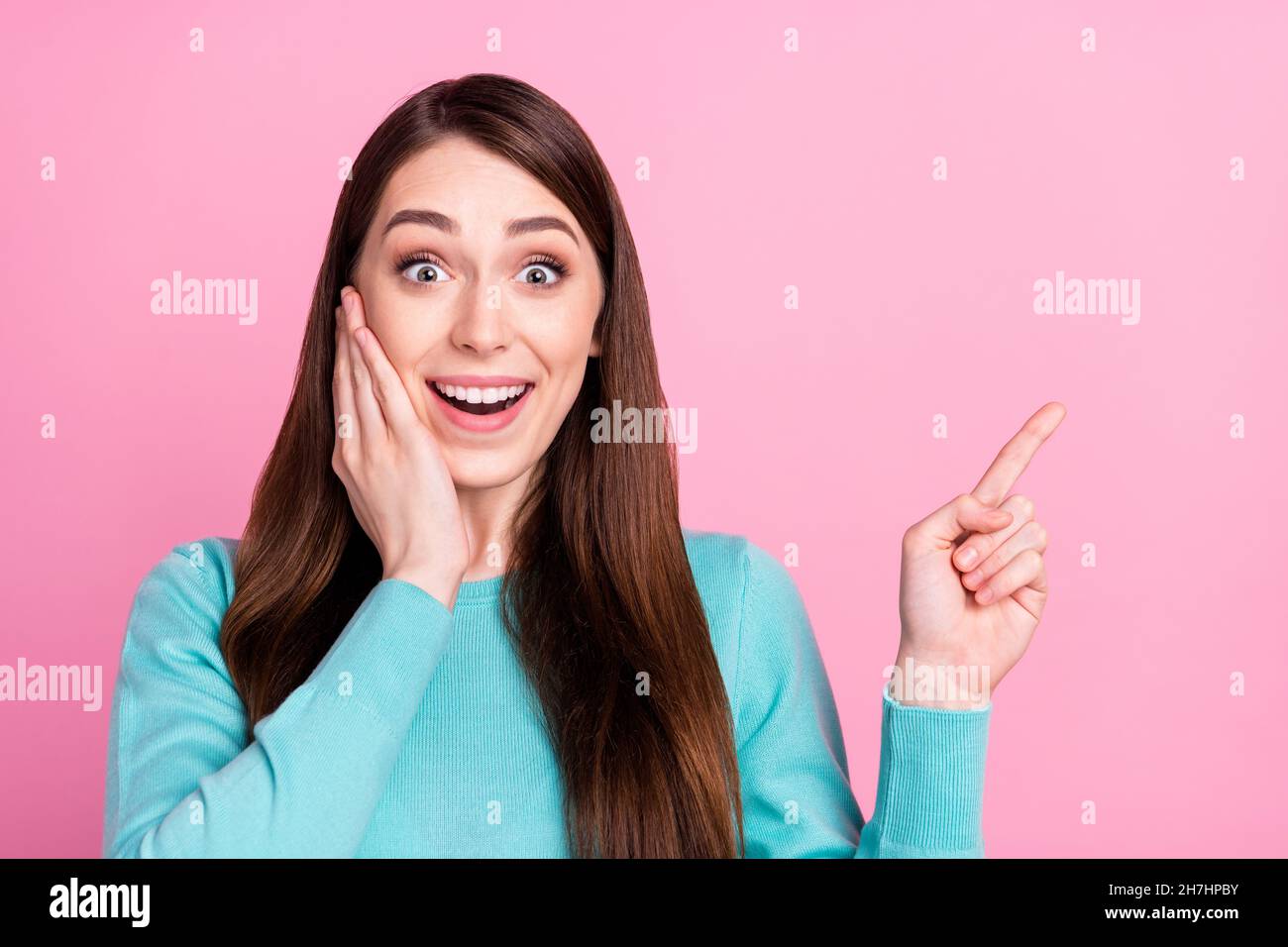 Photo of astonished happy surprised young woman hold hand cheek point ...