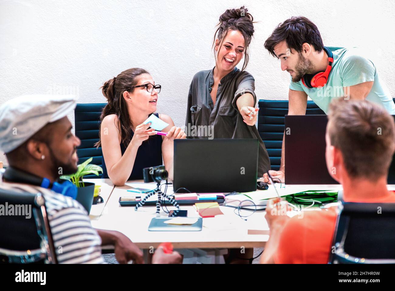 Millenial friends employees group workers on computer at startup studio ...