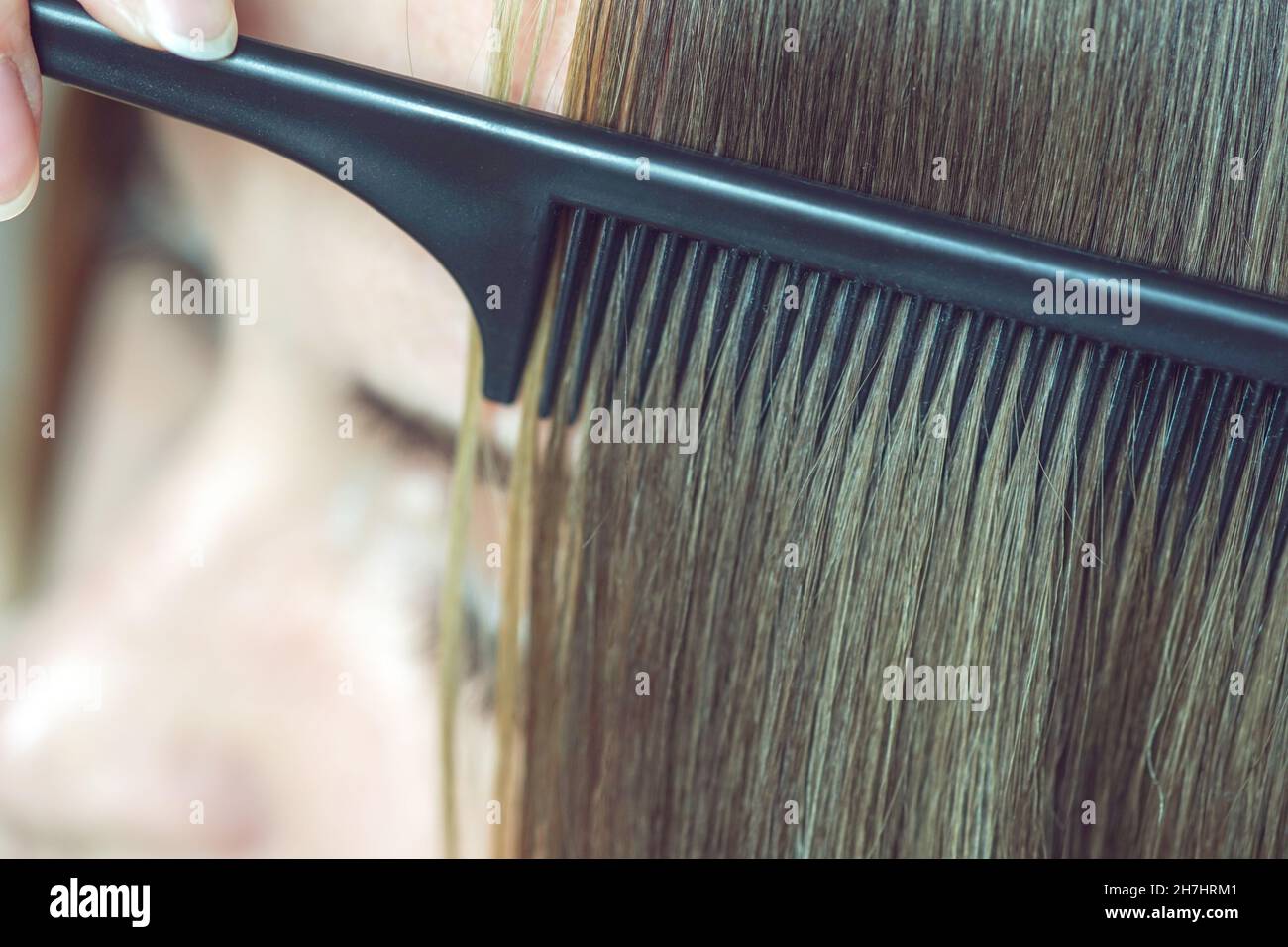 The process of combining a fine black comb for brown hair Stock Photo ...