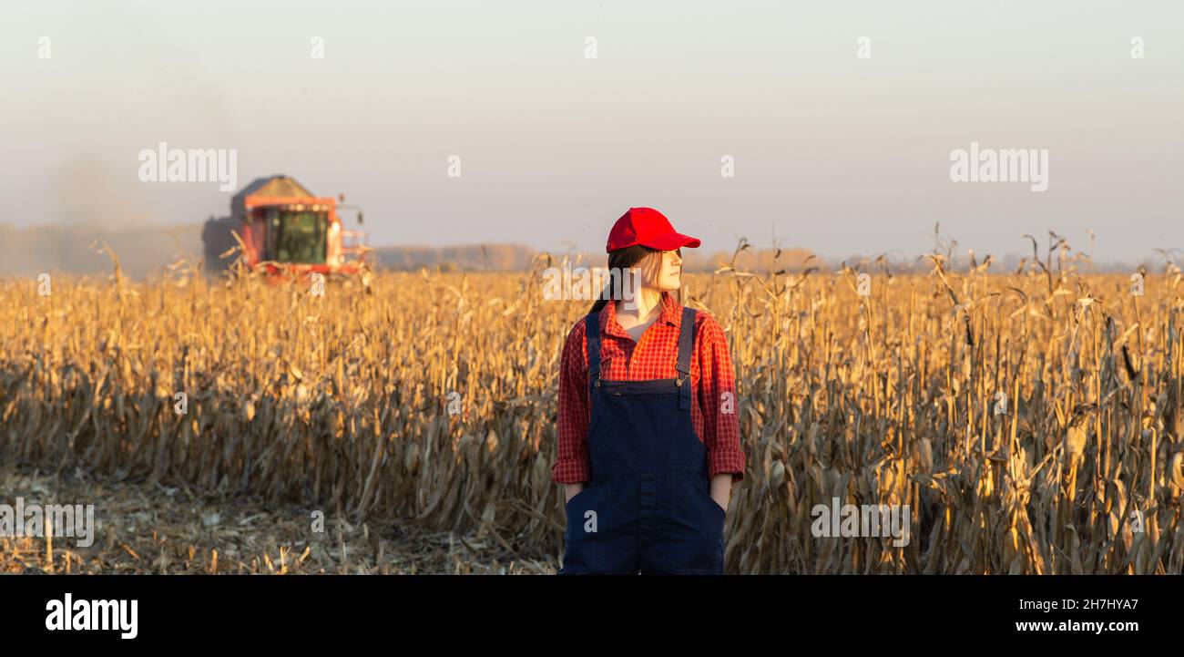 Young farmer girl in the corn field. Agricultural machinery in ...