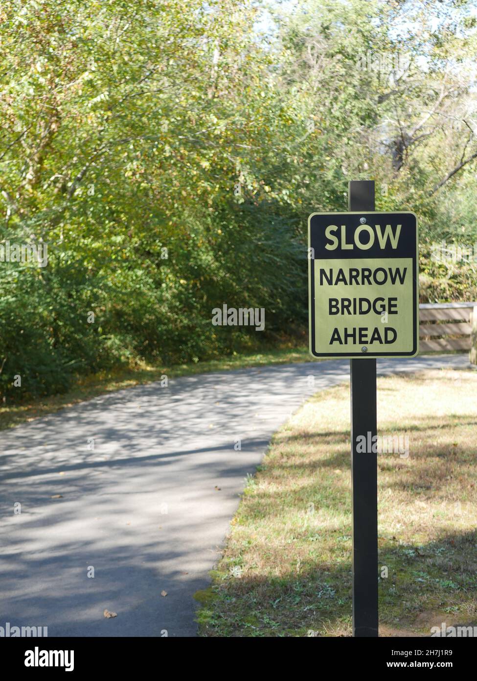 Vertical shot of a sign 'slow, narrow bridge ahead' by the road Stock ...