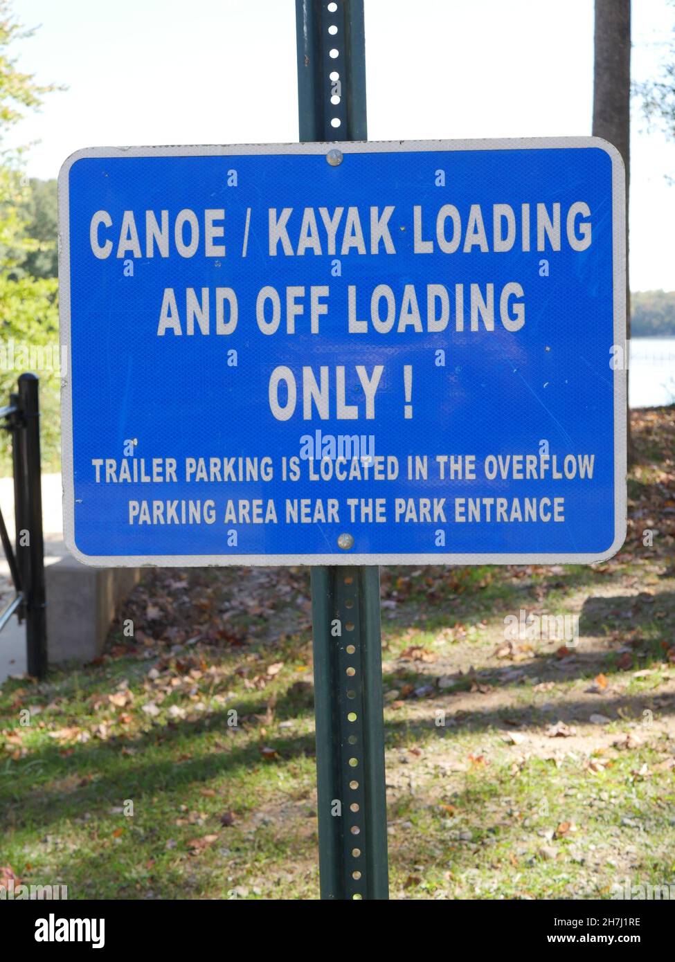 Vertical shot of a blue sign with the text 'canoe/kayak loading and off ...