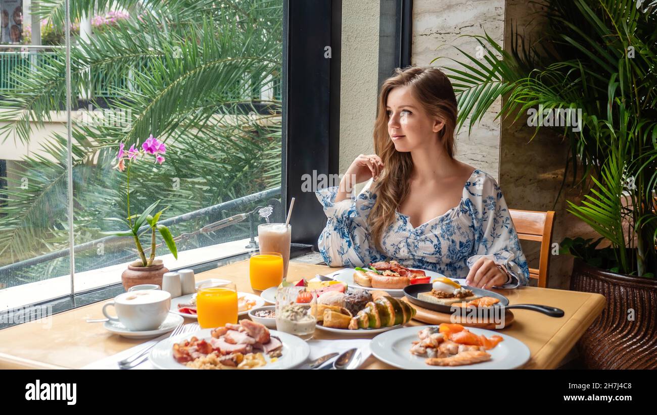 Modern female businesswoman eat breakfast buffet in urban cafe with ...