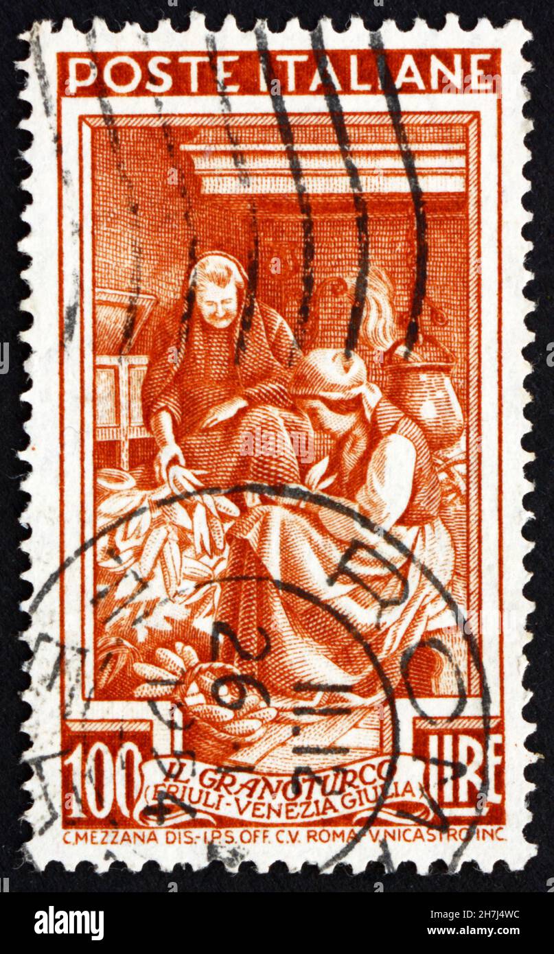 ITALY - CIRCA 1950: a stamp printed in the Italy shows Husking Corn ...