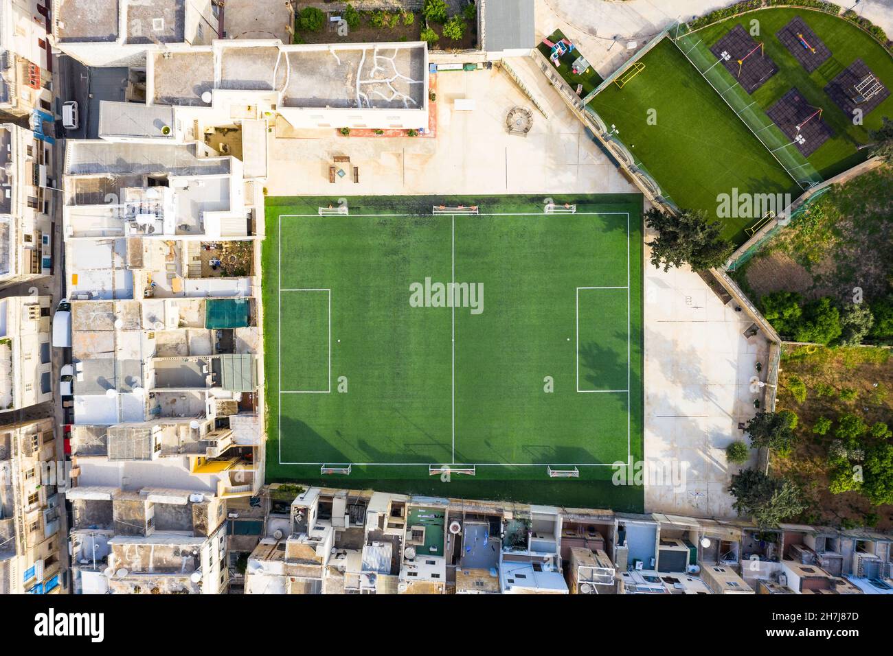 Aerial view of a football field in a residential area, among stone ...