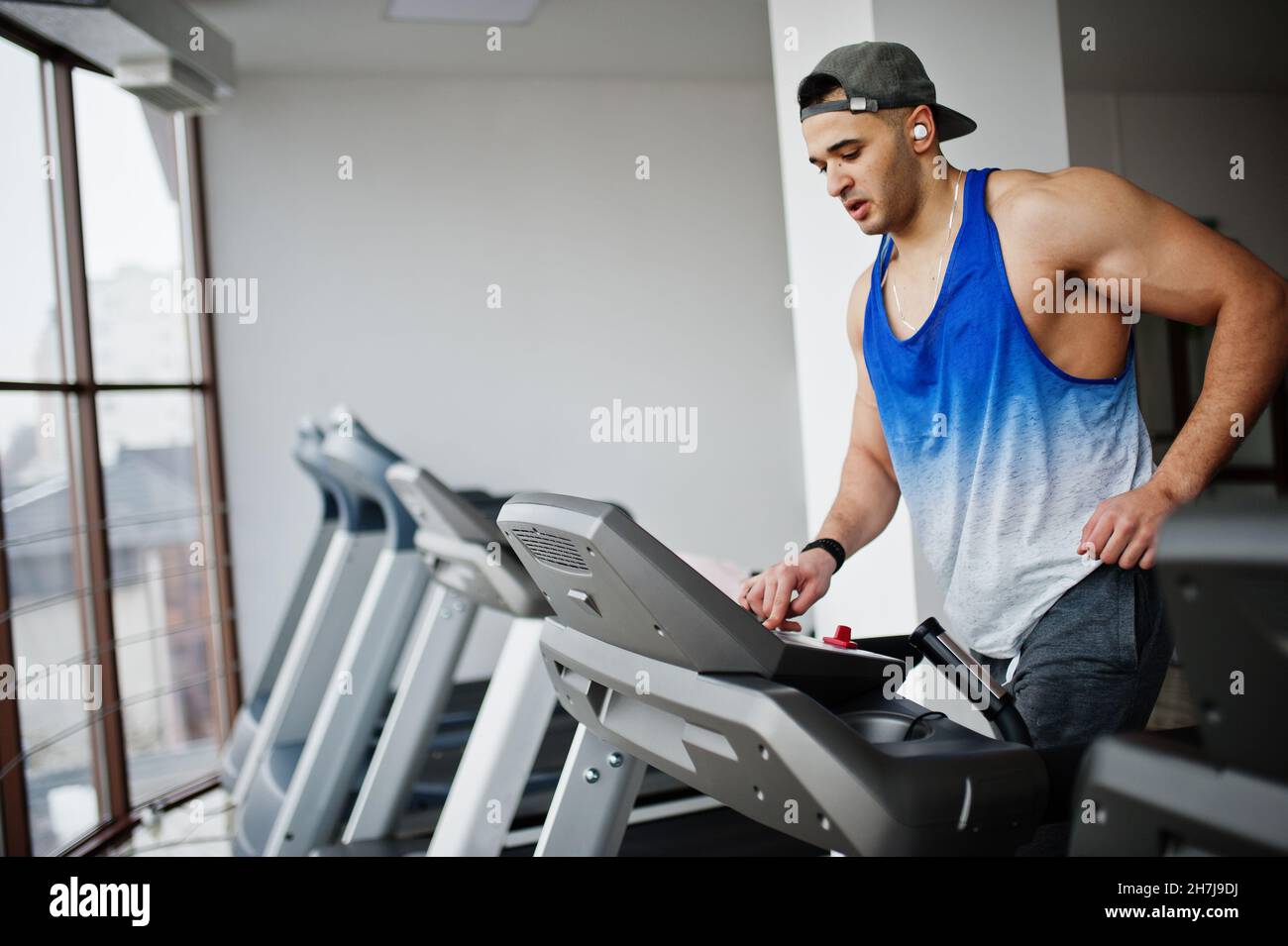 Fit and muscular arabian man running on treadmill in gym Stock Photo ...