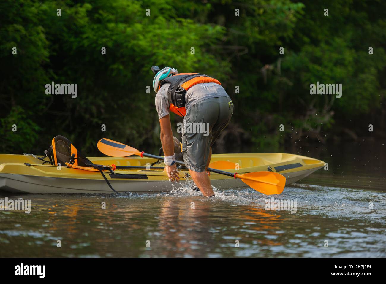 Healthy and fit senior is getting the kayak ready so he can use it ...