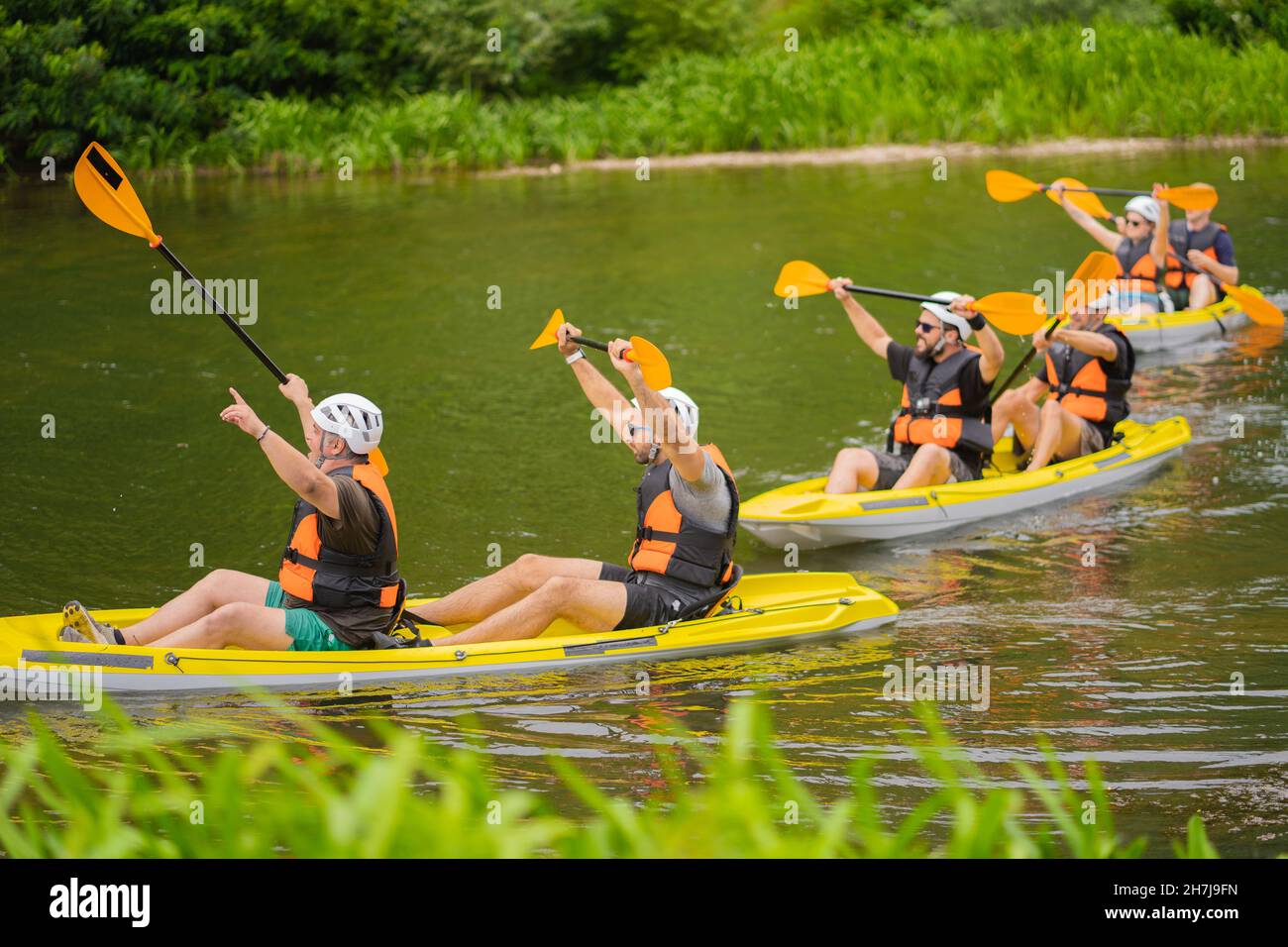 Group of friends are kayaking together in pairs while screaming out of ...