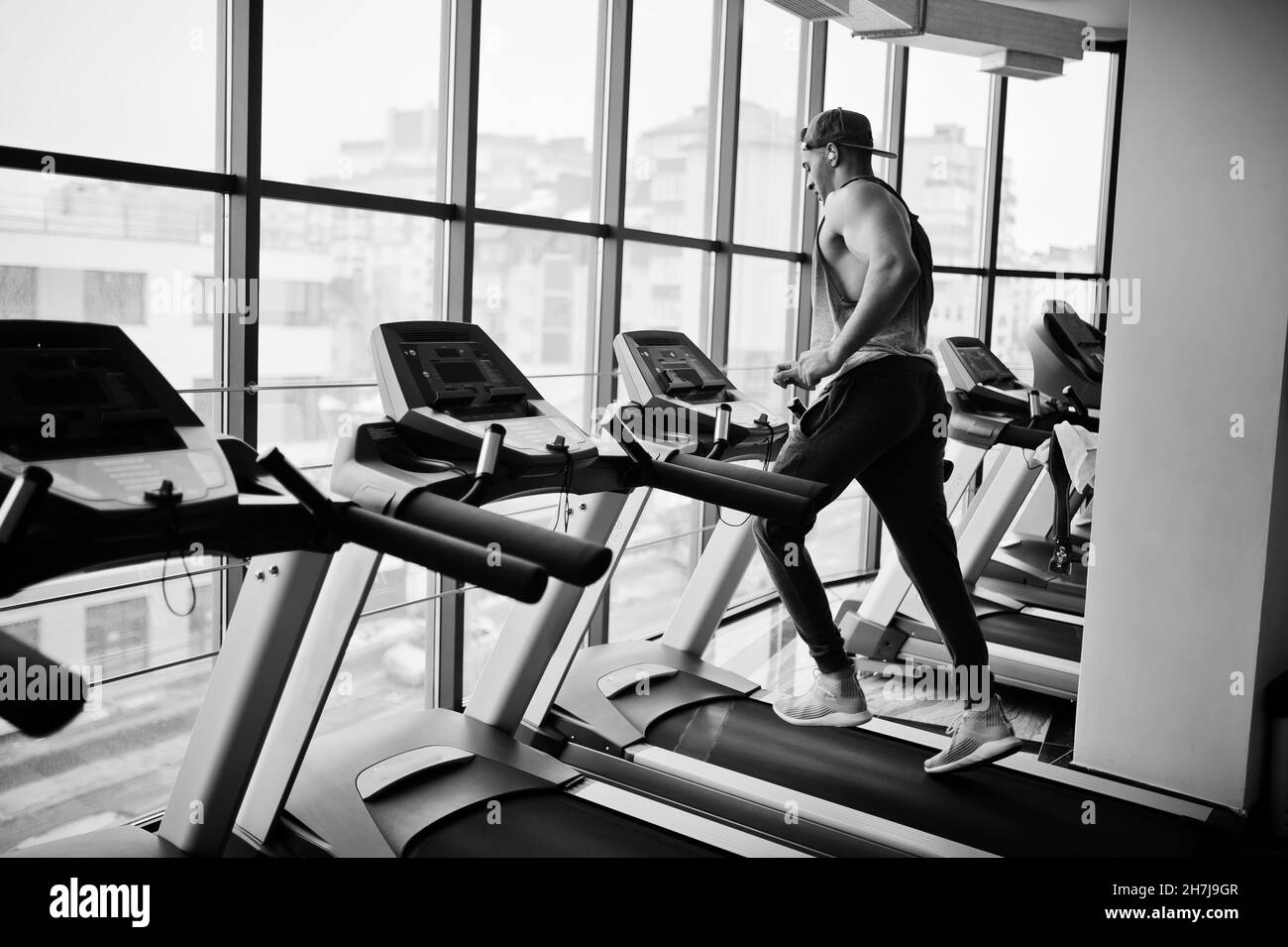 Fit and muscular arabian man running on treadmill in gym Stock Photo ...
