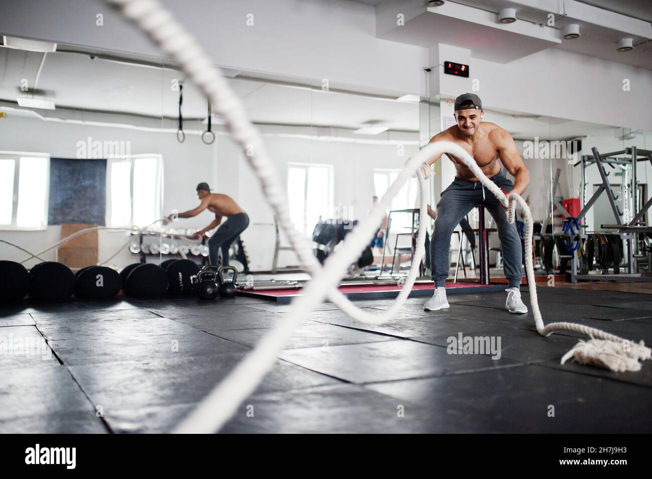 Fit and muscular arabian man working out with heavy ropes in gym Stock ...