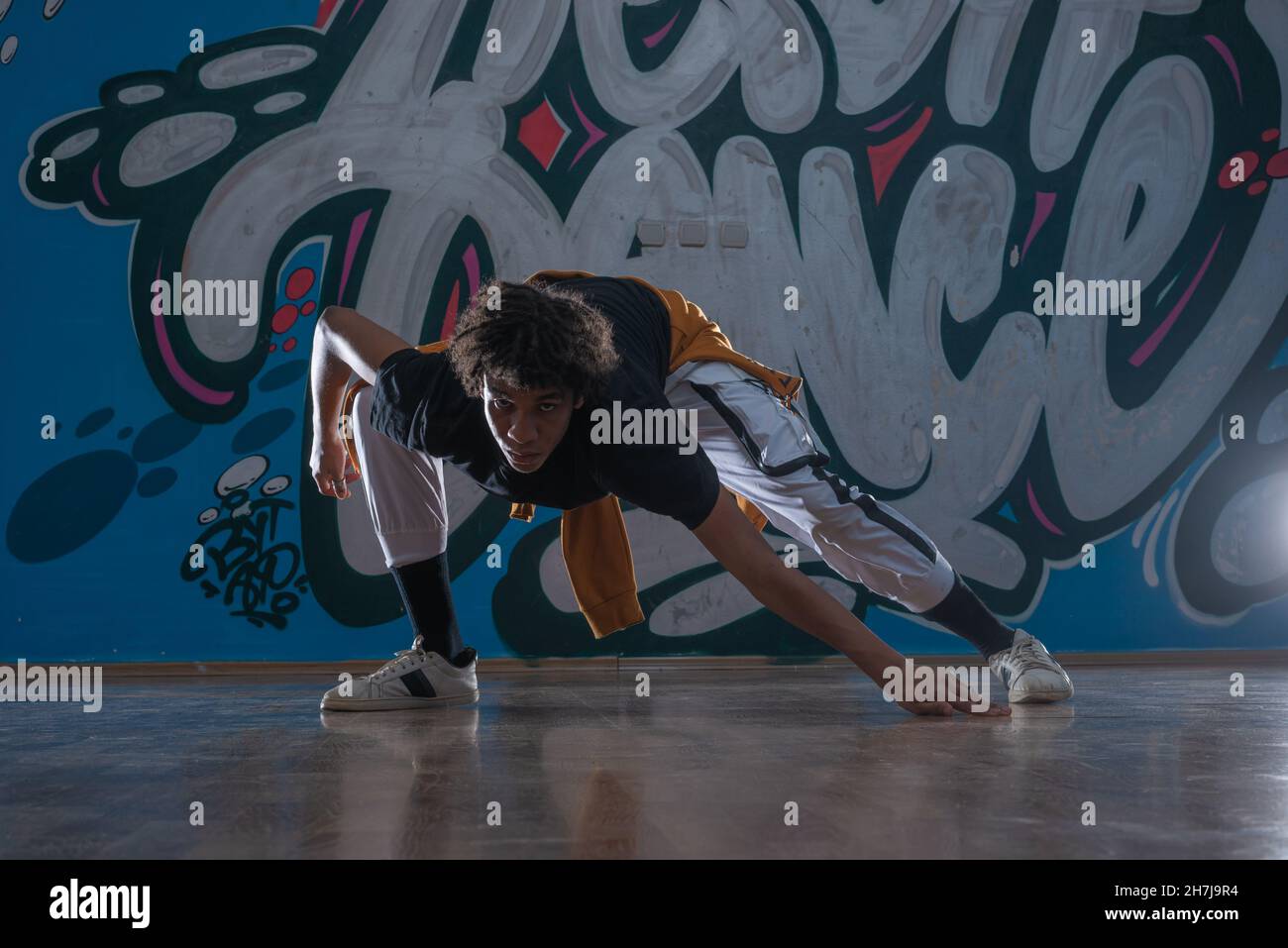 African American hip hop dancer (breakdancer) performing over graffiti ...