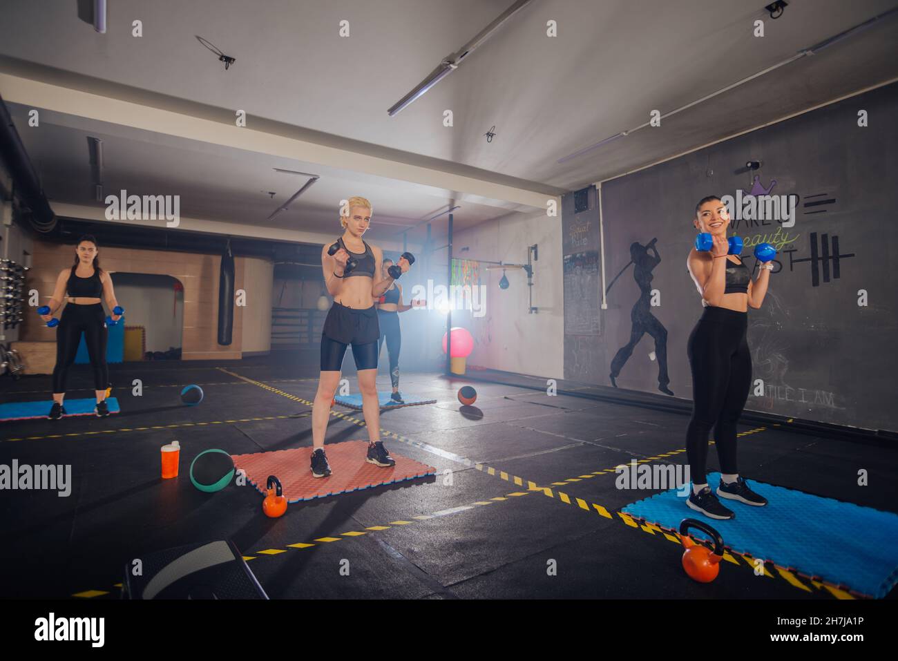 Group of good-looking sportswomen training total body fitness indoors ...