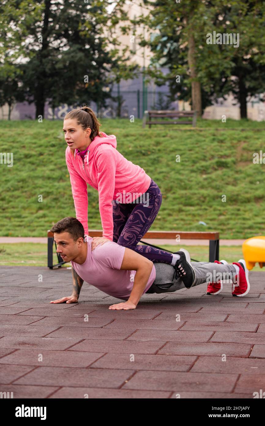 Attractive and handsome guy is trying so hard to do a push up while his ...