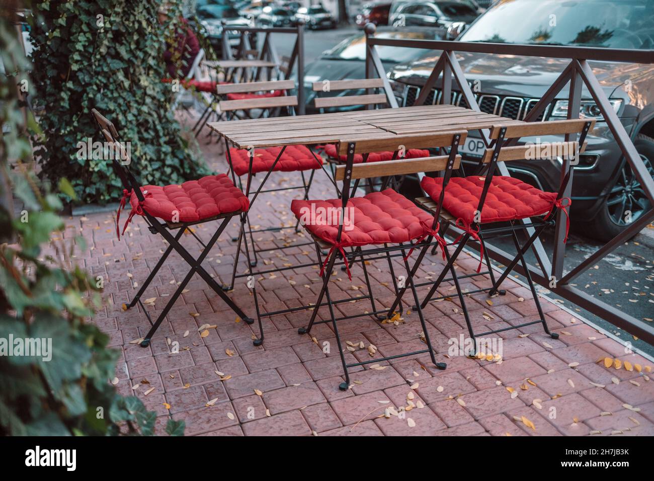 Empty wooden tables of cozy and beautiful street cafe oudoors during ...
