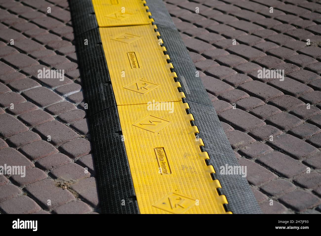 cable hose protector on paving slabs. Safety rubber cable protection ...