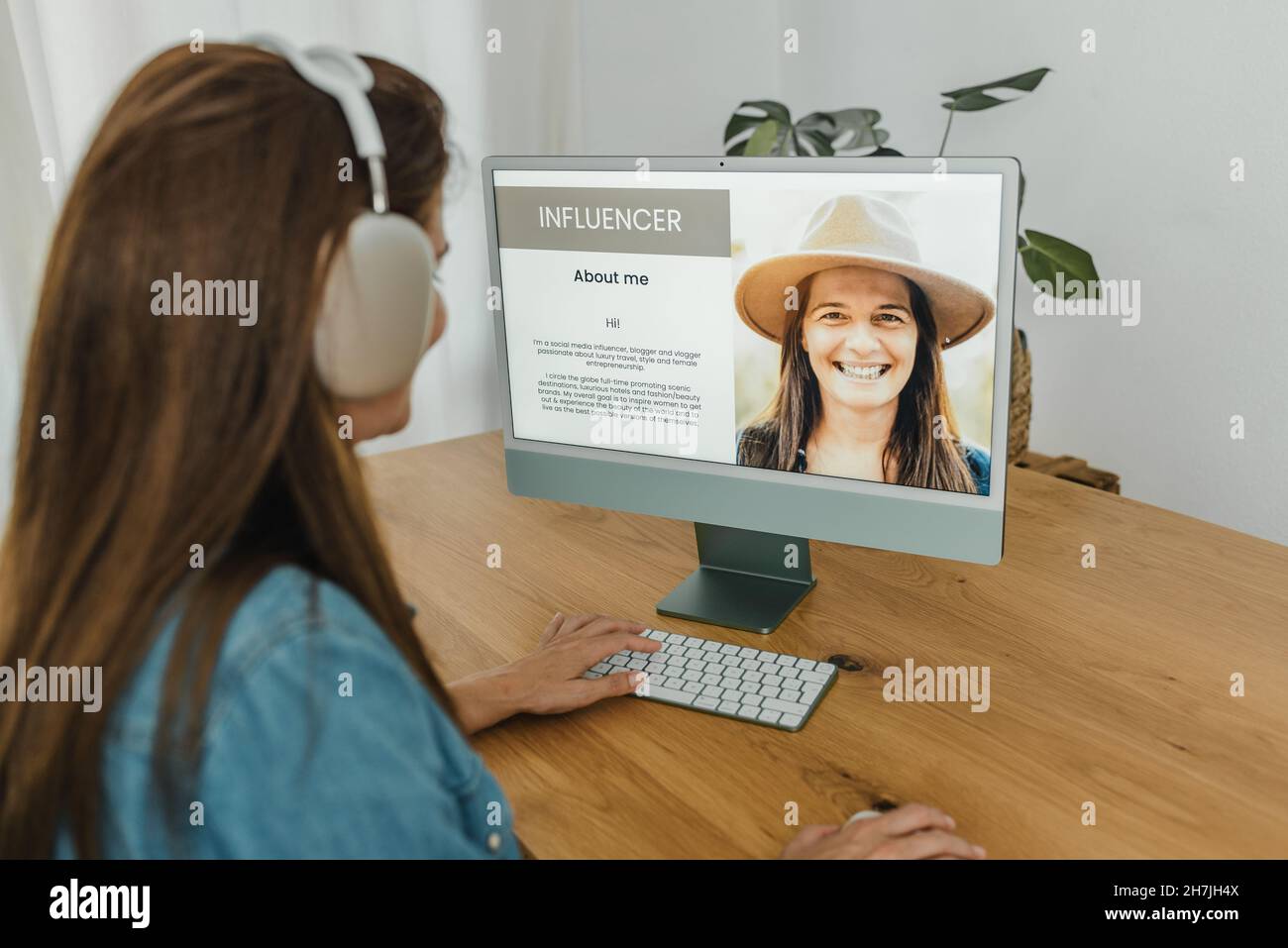 Female influencer using computer and browsing blog Stock Photo - Alamy